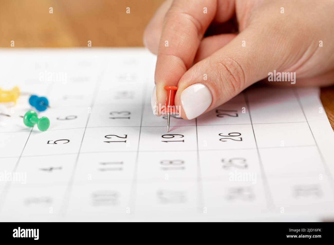 red Hand pin stuck on the day of the month in the calendar, business ...