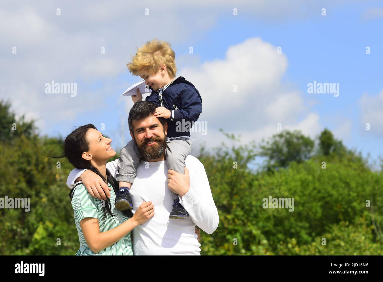 Happy family mother, father and child with toy paper plane. Happy ...