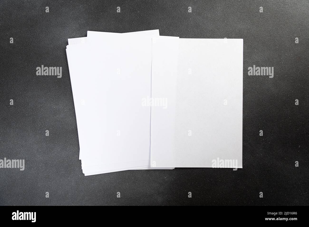 White business card sheet of paper a4 stack on a dark table. Clean ...