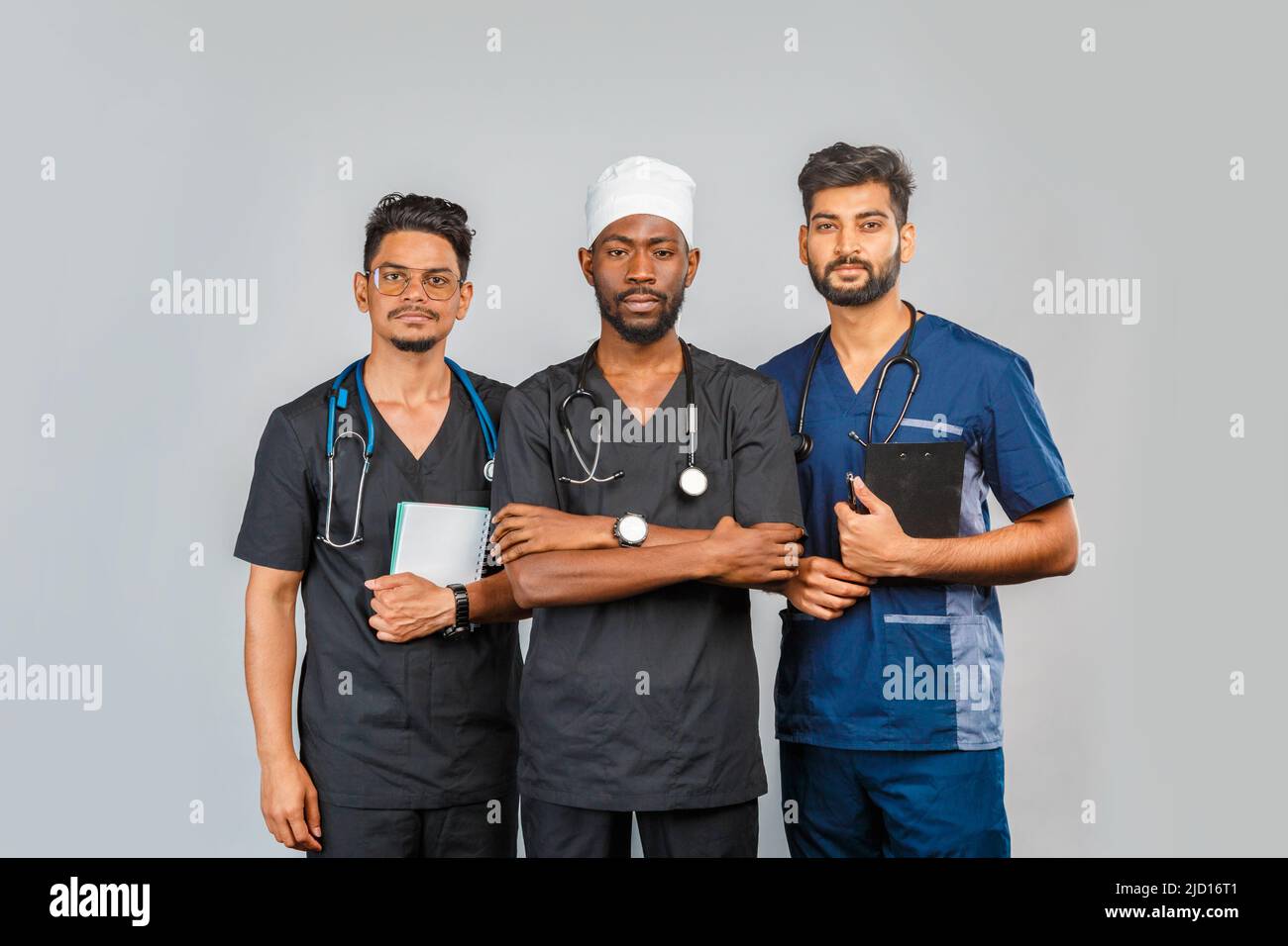 attractive medical team standing together over light gray background ...
