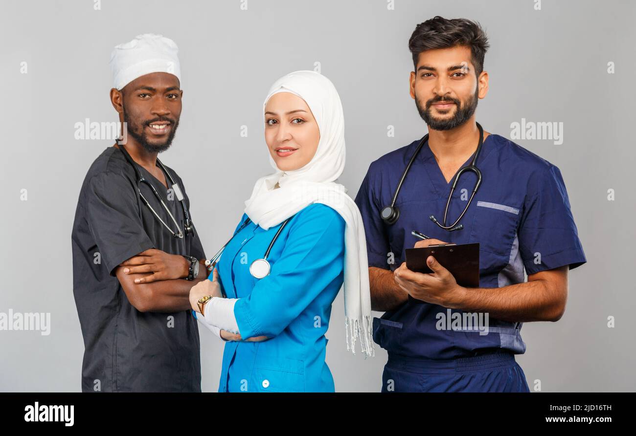 Group of paramedics smiling over gray background. muslim doctor woman ...