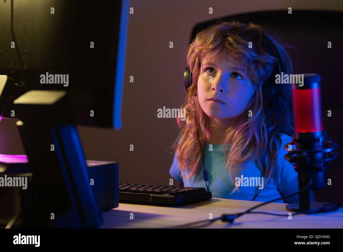 Kid using pc at night. Child with computer in a dark room. Social ...