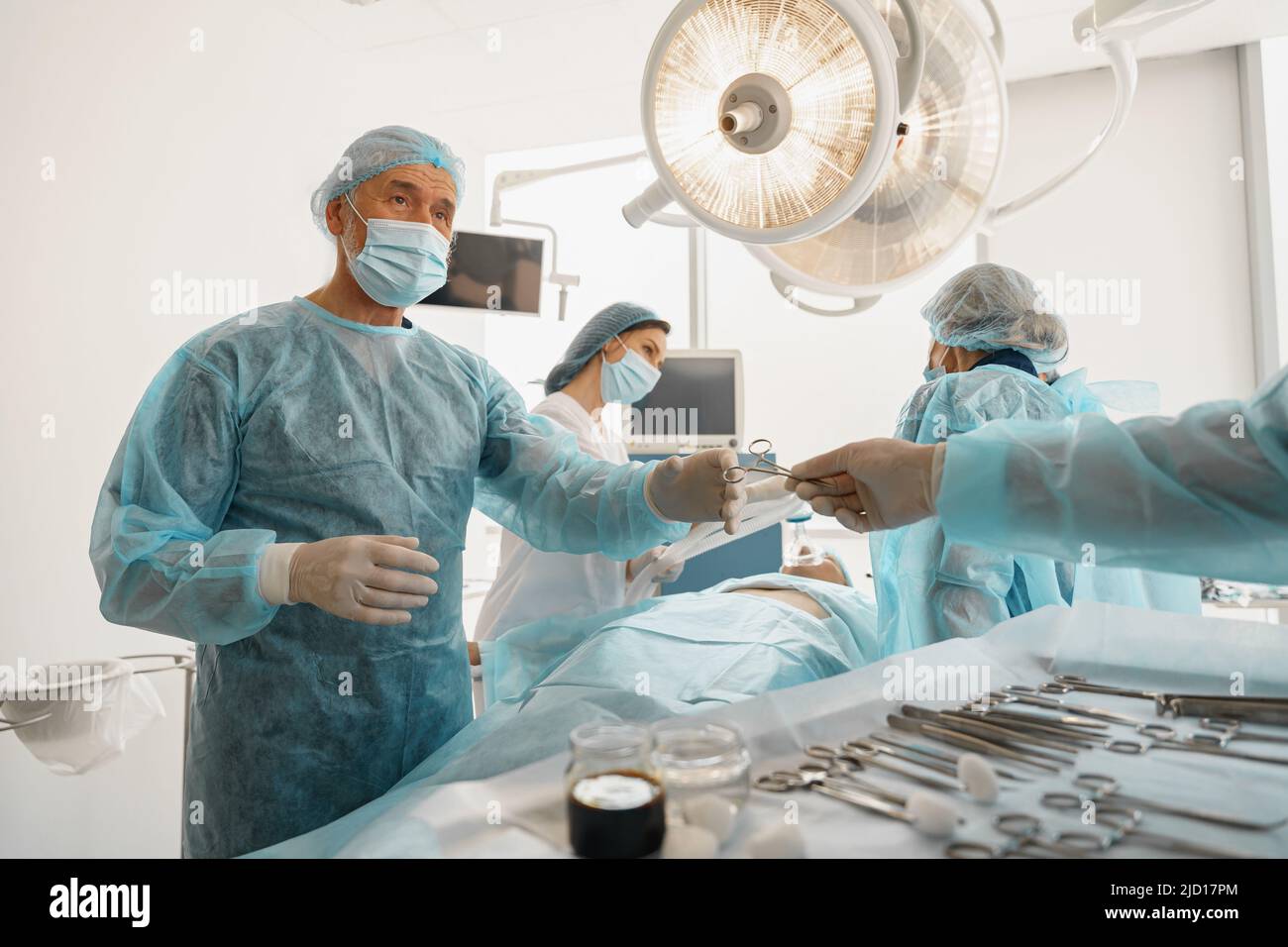 Assistant hands out instruments surgeon during surgery in the operating ...
