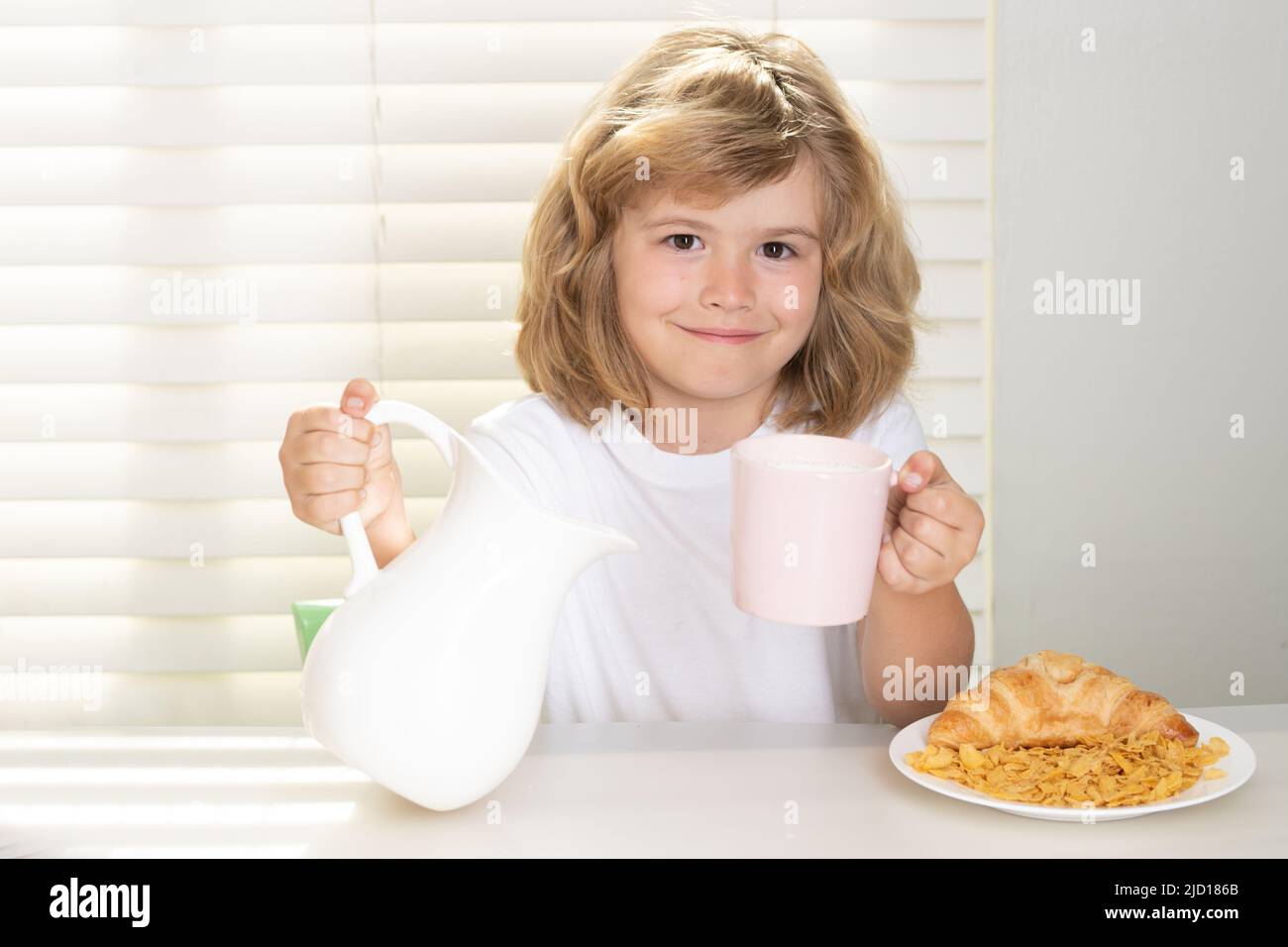 School chil pouring whole cows milk for breakfast. Funny blonde little ...