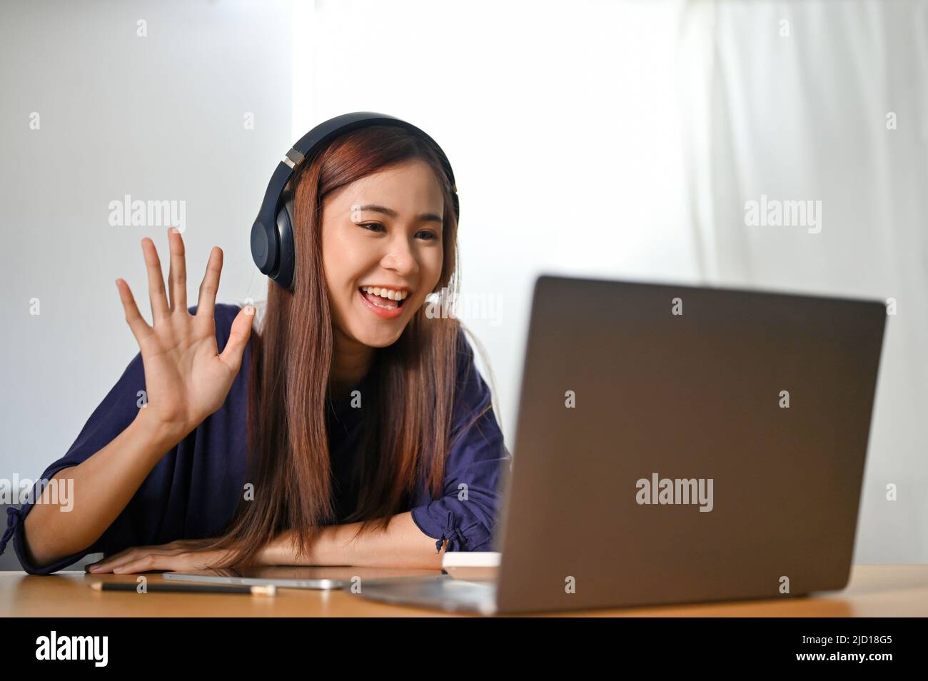 Cheerful and attractive Asian female tutor is tutoring her students on ...