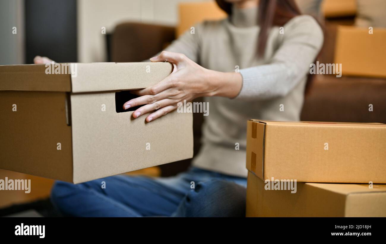 A female holding a box. Female online shop owner packing a customer's ...