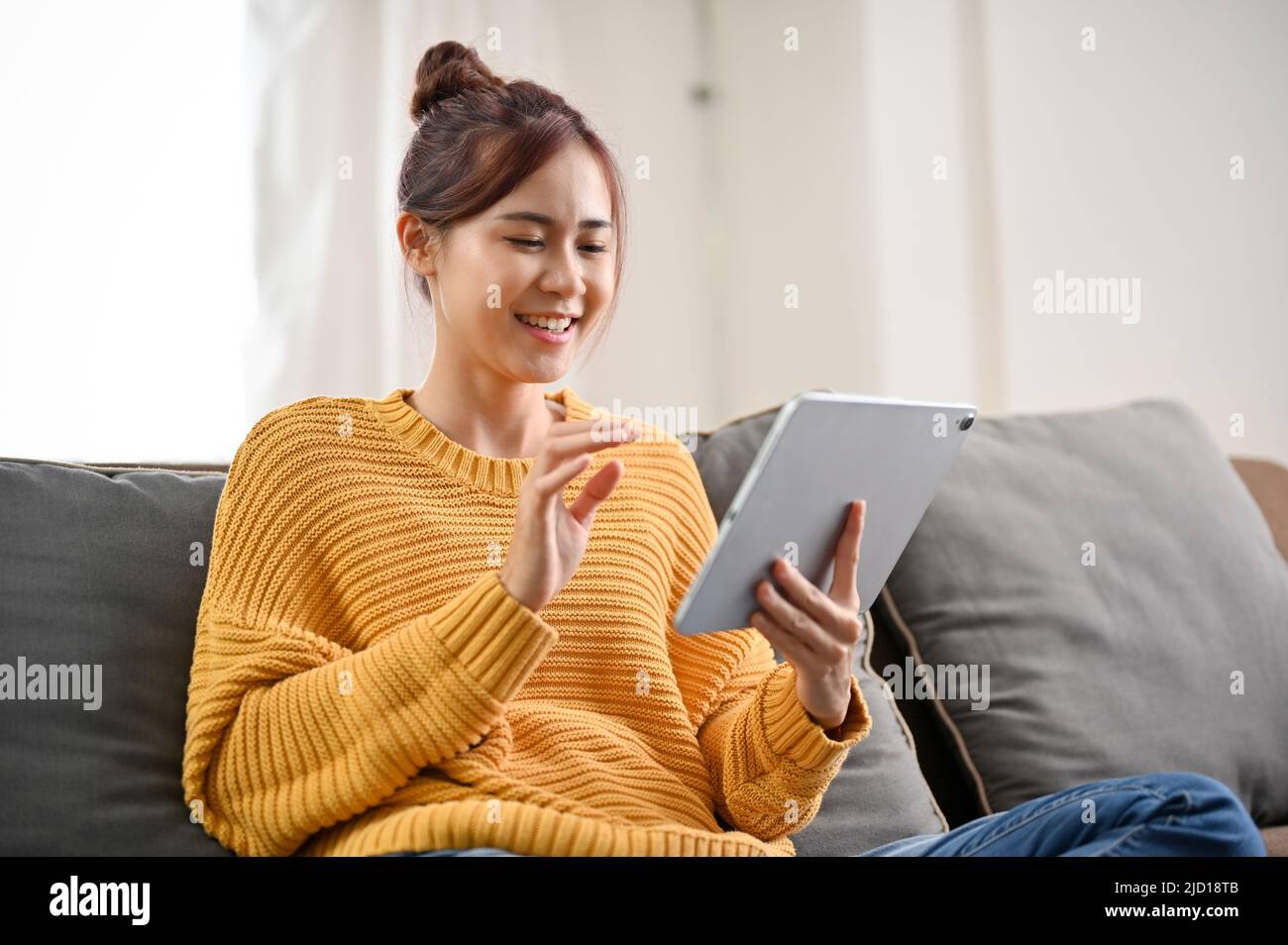 Attractive beautiful young asian woman sitting on comfortable sofa in ...