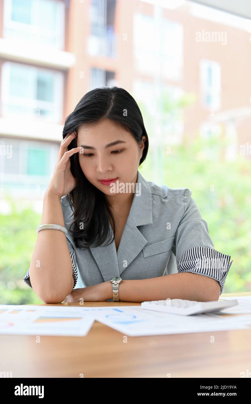 Stressed asian businesswoman or female manager worried about her work ...