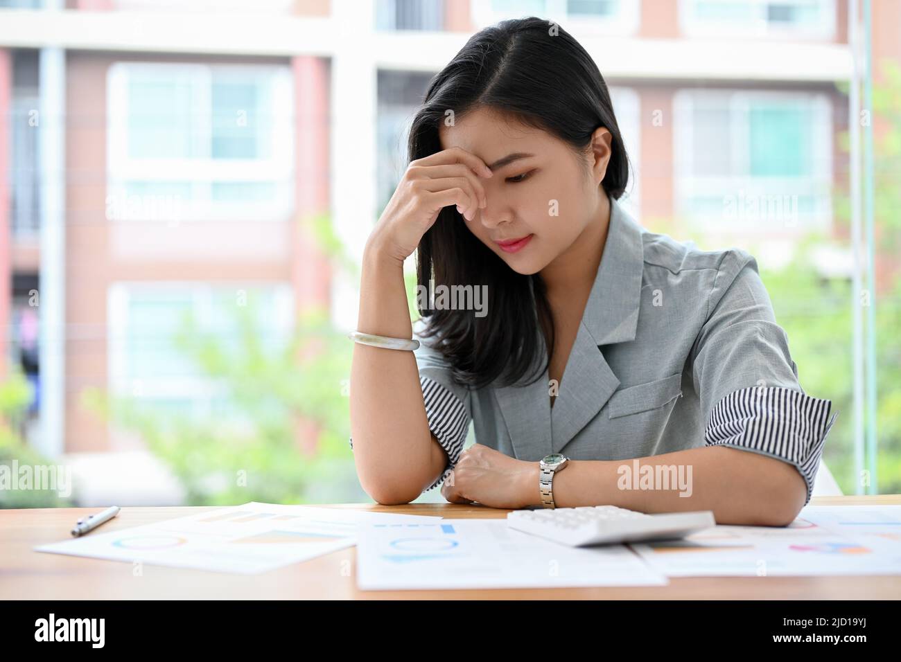 Stressed asian businesswoman or female manager worried about her work ...