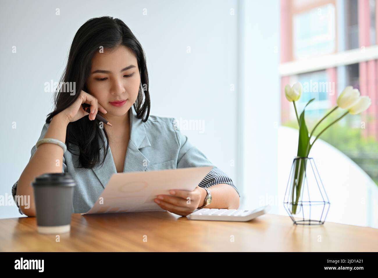 Beautiful asian female accountant checking, reading, analysing the ...