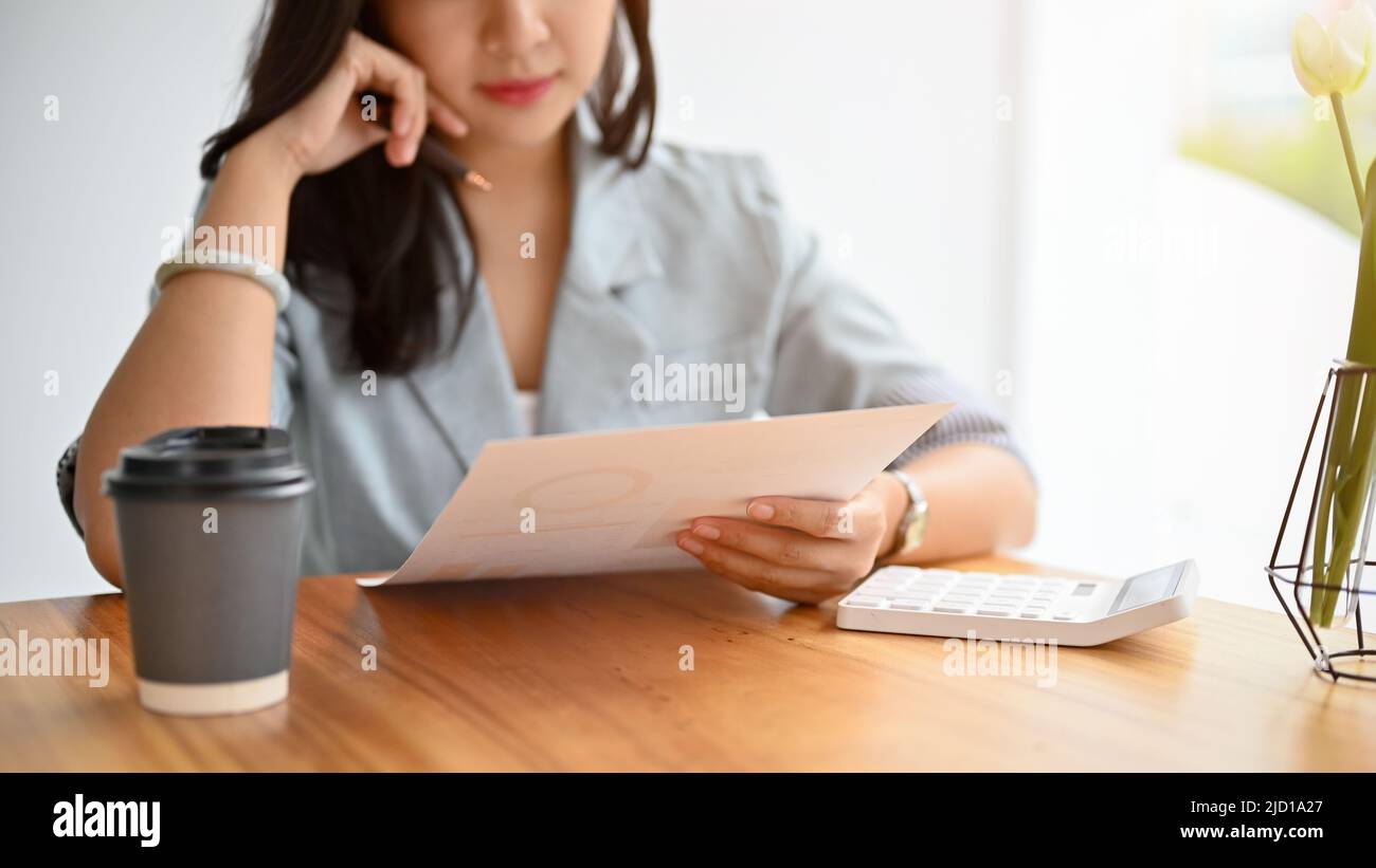 Charming asian female accountant checking, reading, analysing the ...