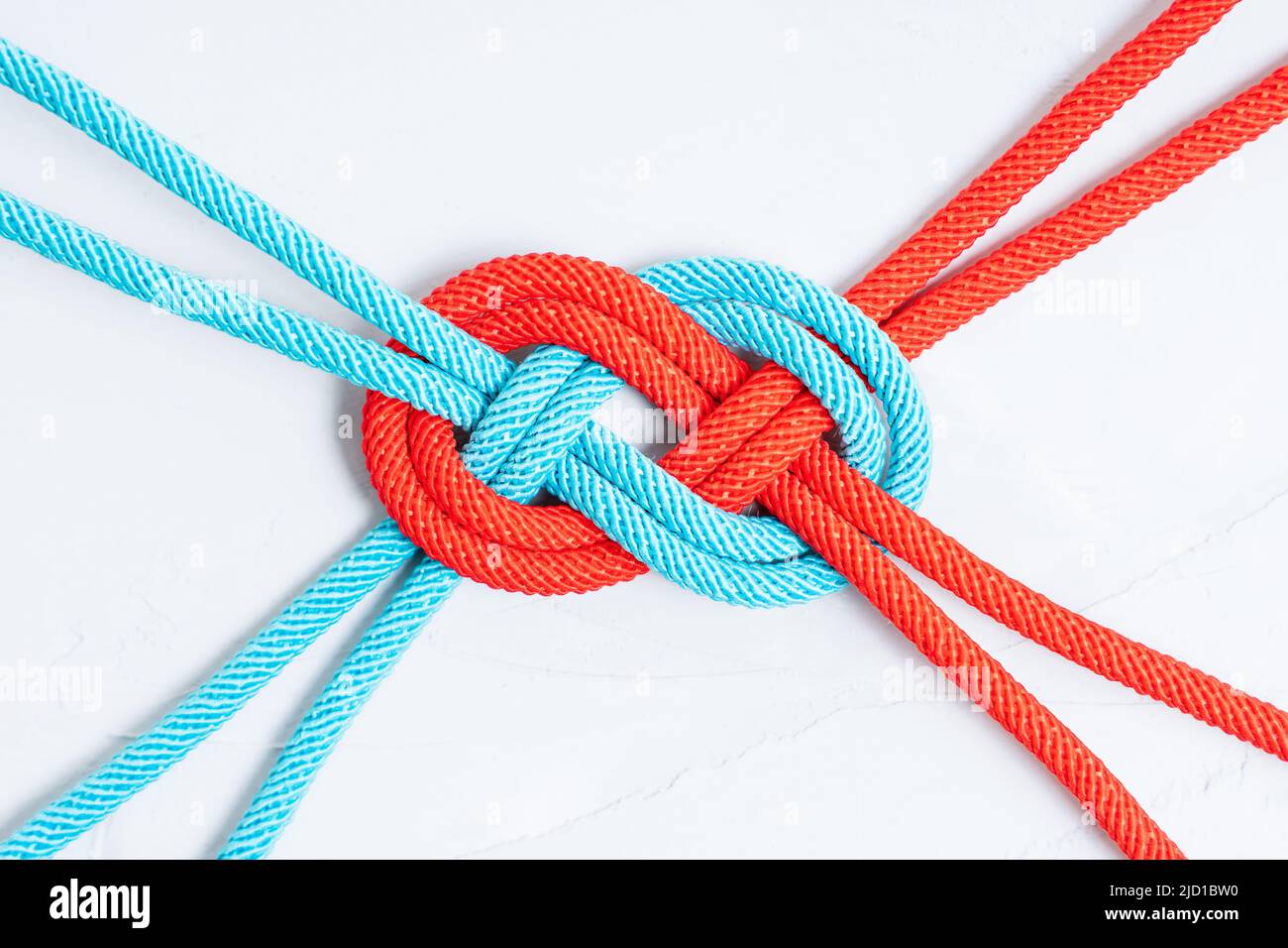 Red and blue cords intertwined in the shape of an infinity sign on a ...