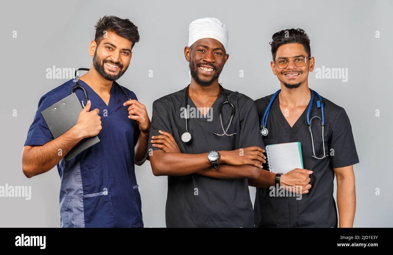 attractive medical team standing together over light gray background ...