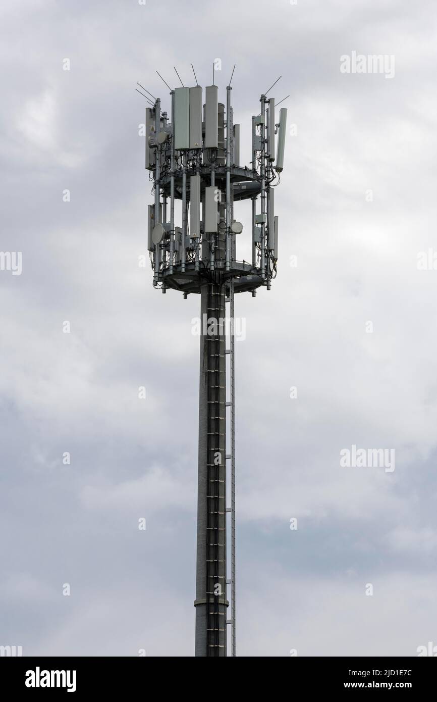 Mobile phone mast, transmission mast in front of dark cloudy sky ...
