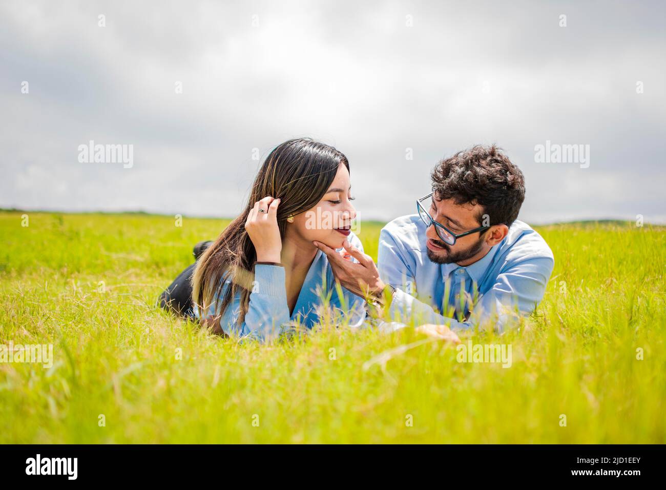 A Couple Lying On The Grass Looking At Each Other Young Couple In Love Lying On The Grass 