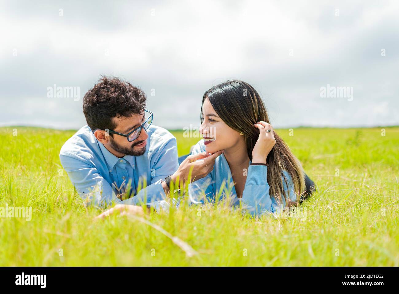 Young Couple In Love Lying On The Grass Touching Each Others Faces Two People In Love Lying On 