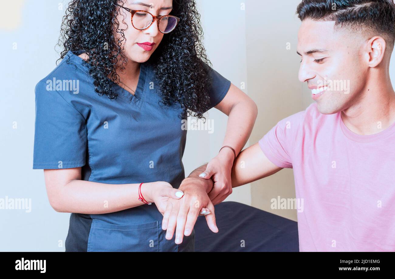 Physiotherapist with patient wrist assessment, wrist rehabilitation ...