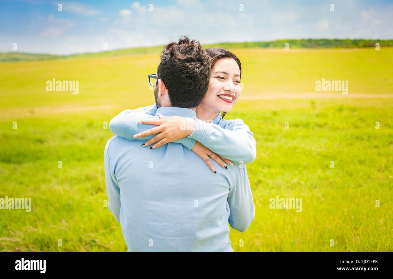 Close up of a happy couple hugging in the field, a young couple in love ...