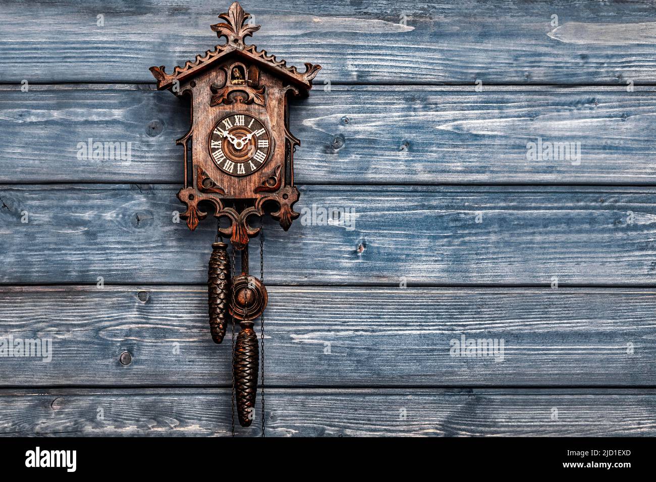 Antique Black Forest cuckoo clock in front of blue wooden wall, studio ...