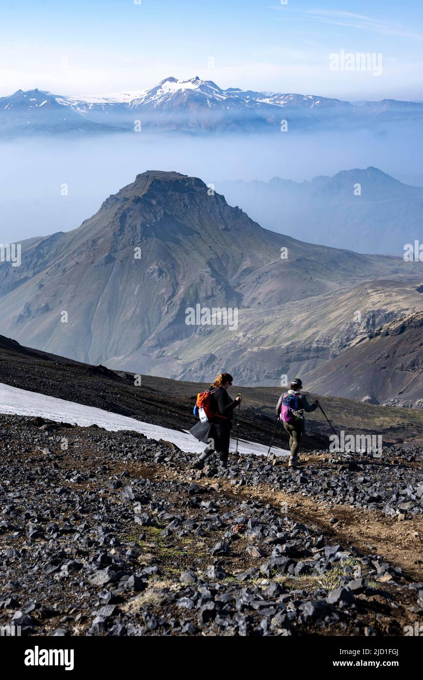 Two hikers on hiking trail through volcanic landscape, view of mountain ...
