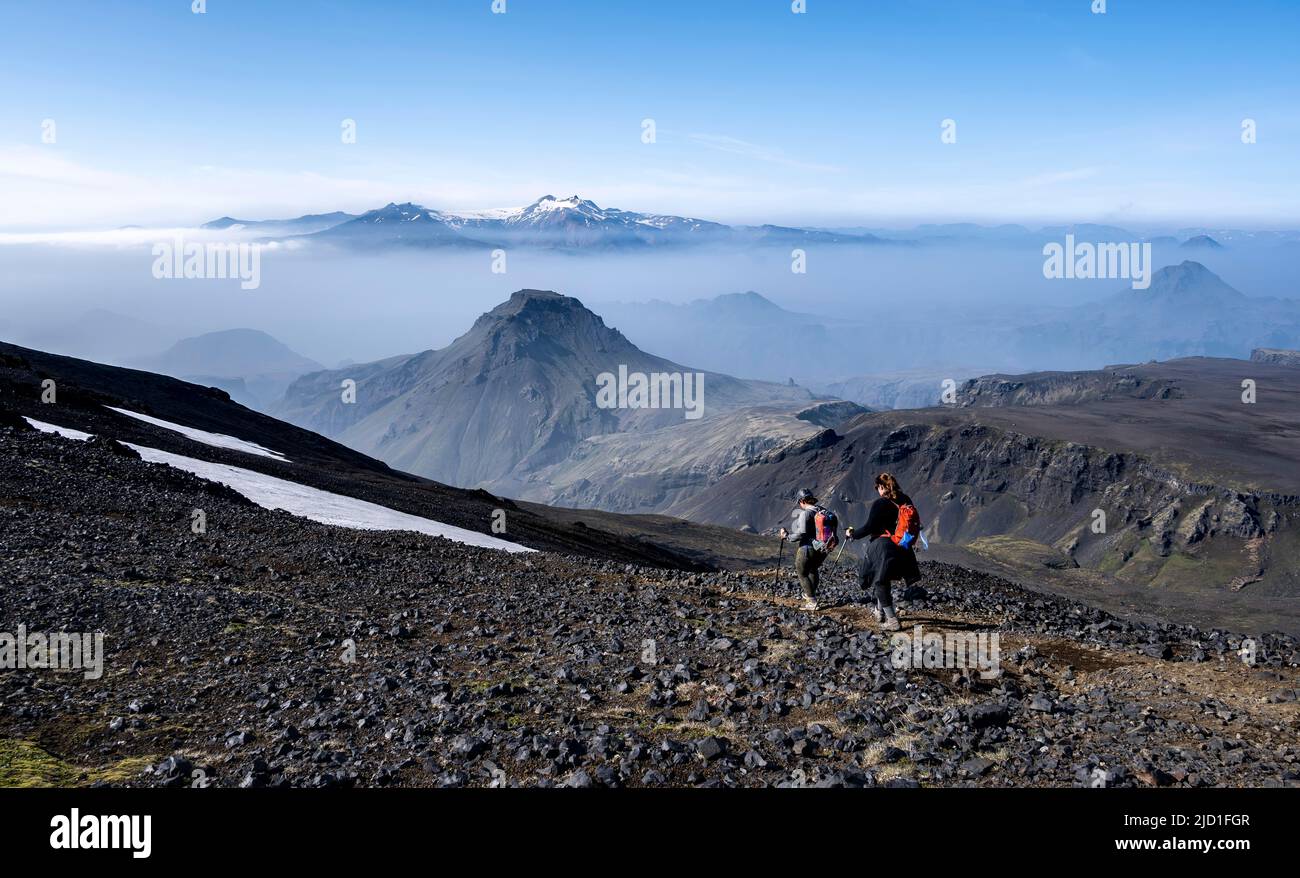 Two hikers on hiking trail through volcanic landscape, view of mountain ...