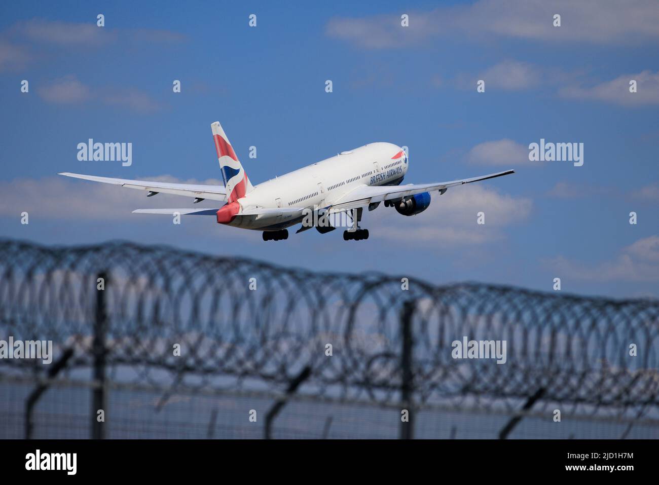 Security fence at Gatwick Airport as a British Airways plane takes off ...