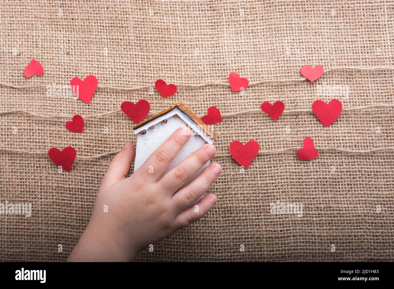Heart shaped icons and paper house on linen threads Stock Photo - Alamy