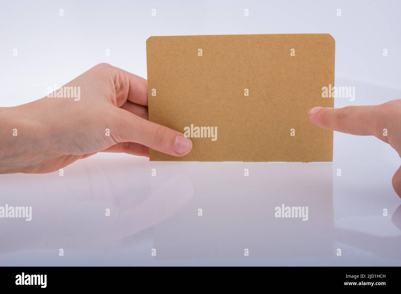 Hand holding a sheet of paper on a white background Stock Photo - Alamy