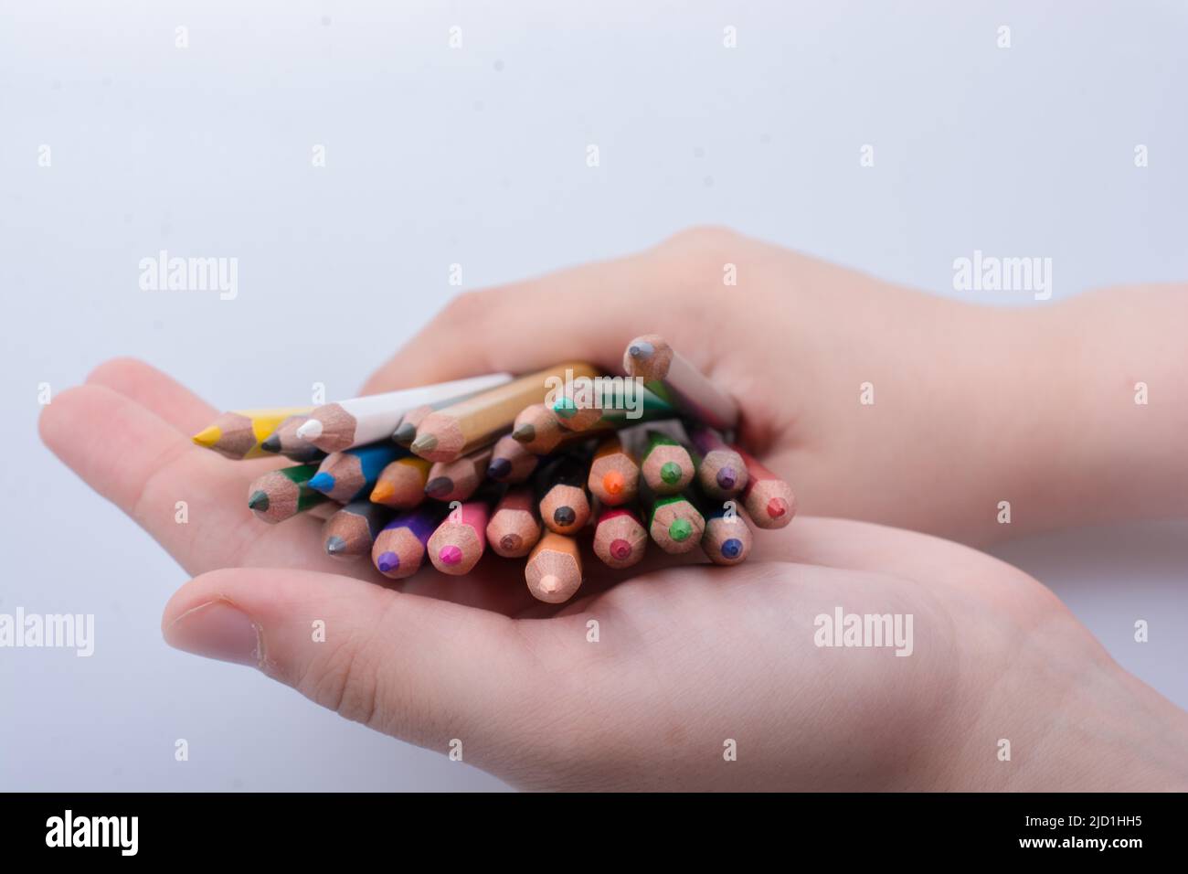 Hand holding color Pencils placed on a white background Stock Photo - Alamy