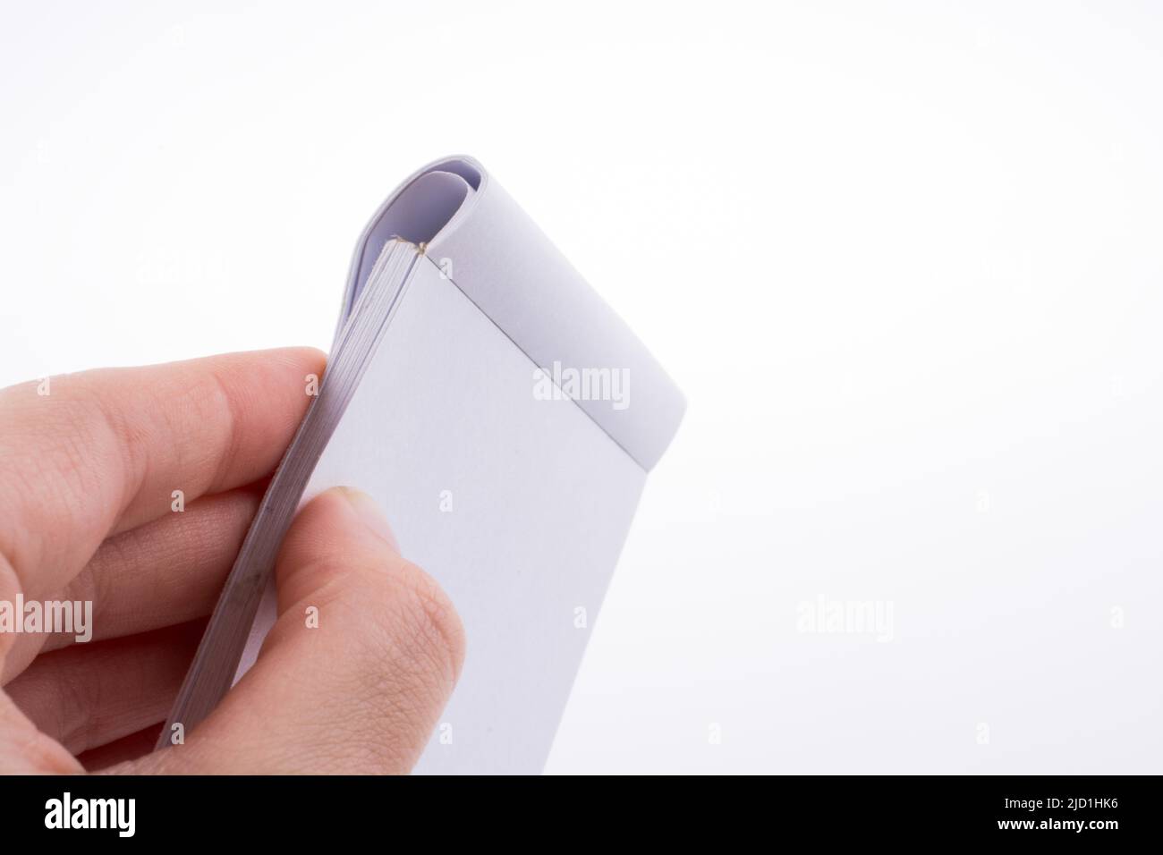 Hand holding white color notebook on a white background Stock Photo - Alamy