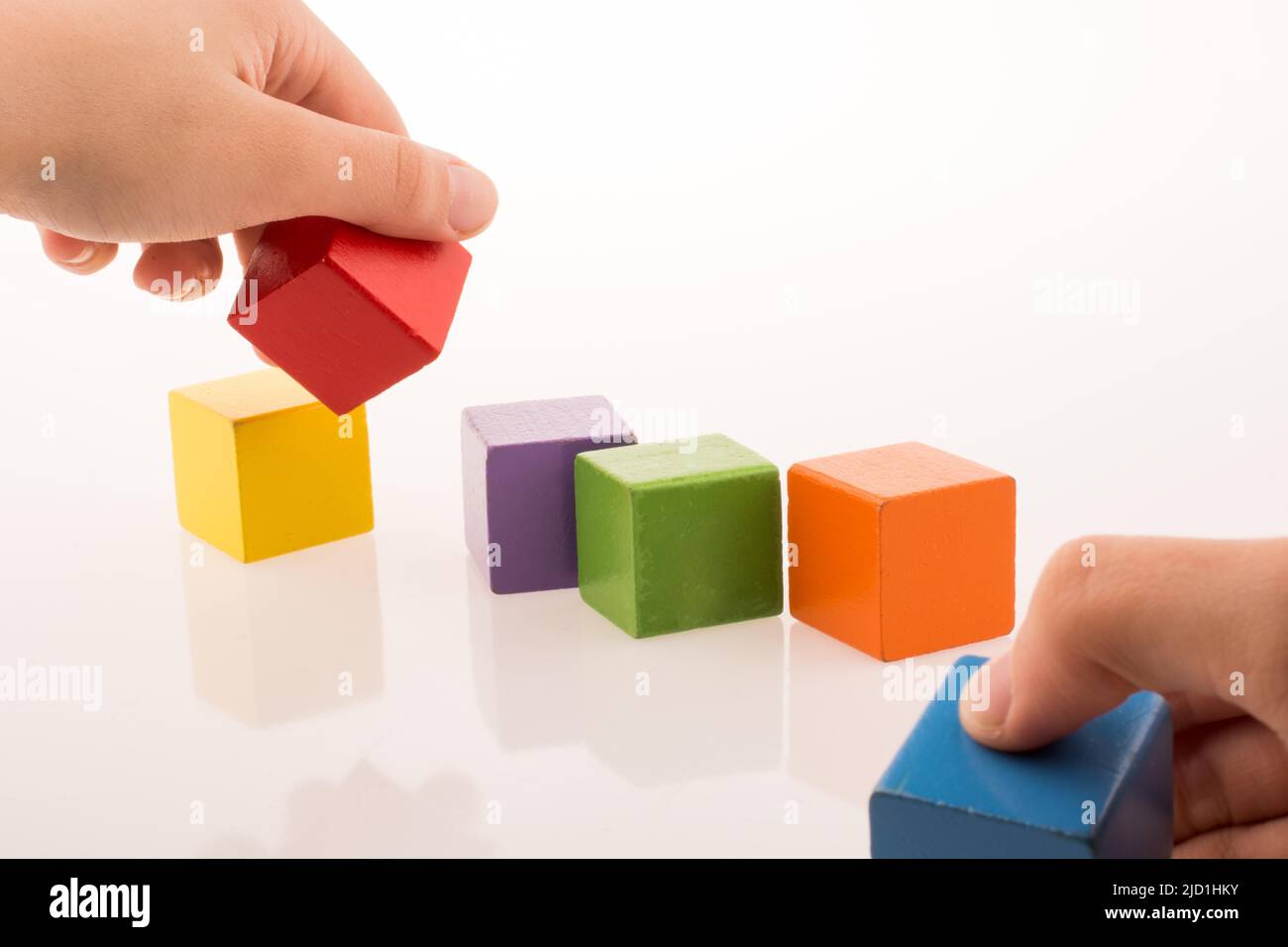 Hand playing with colorful cubes on a white background Stock Photo - Alamy
