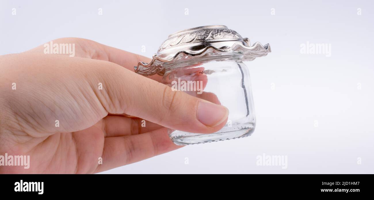 Little empty jar in hand on a white background Stock Photo - Alamy
