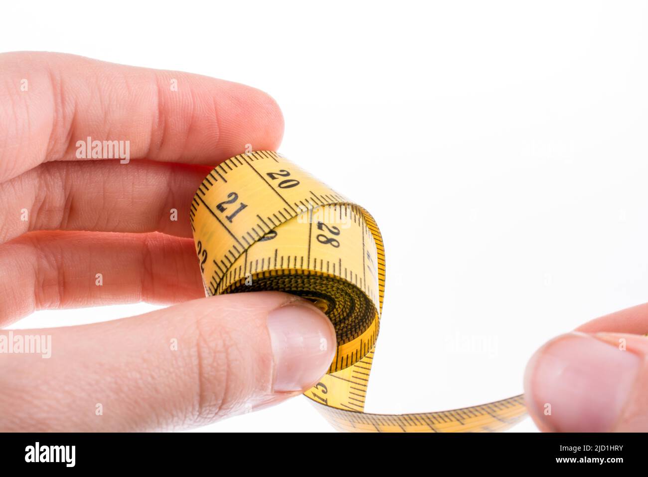 Hand holding a yellow measuring tape Stock Photo - Alamy