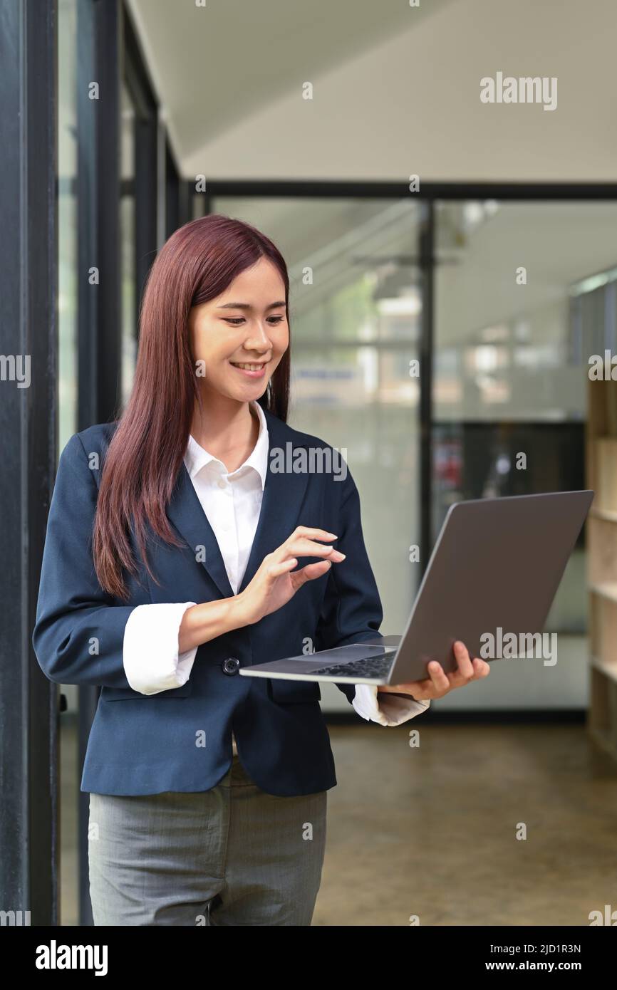 Charming asian female manager standing near glass window at modern ...