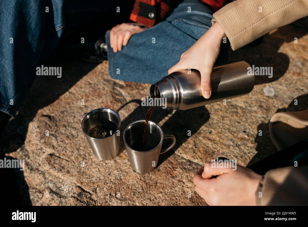 Hand pouring coffee from thermos Stock Photo - Alamy