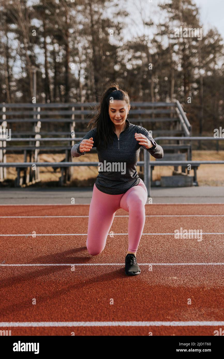 Woman exercising at running track Stock Photo - Alamy
