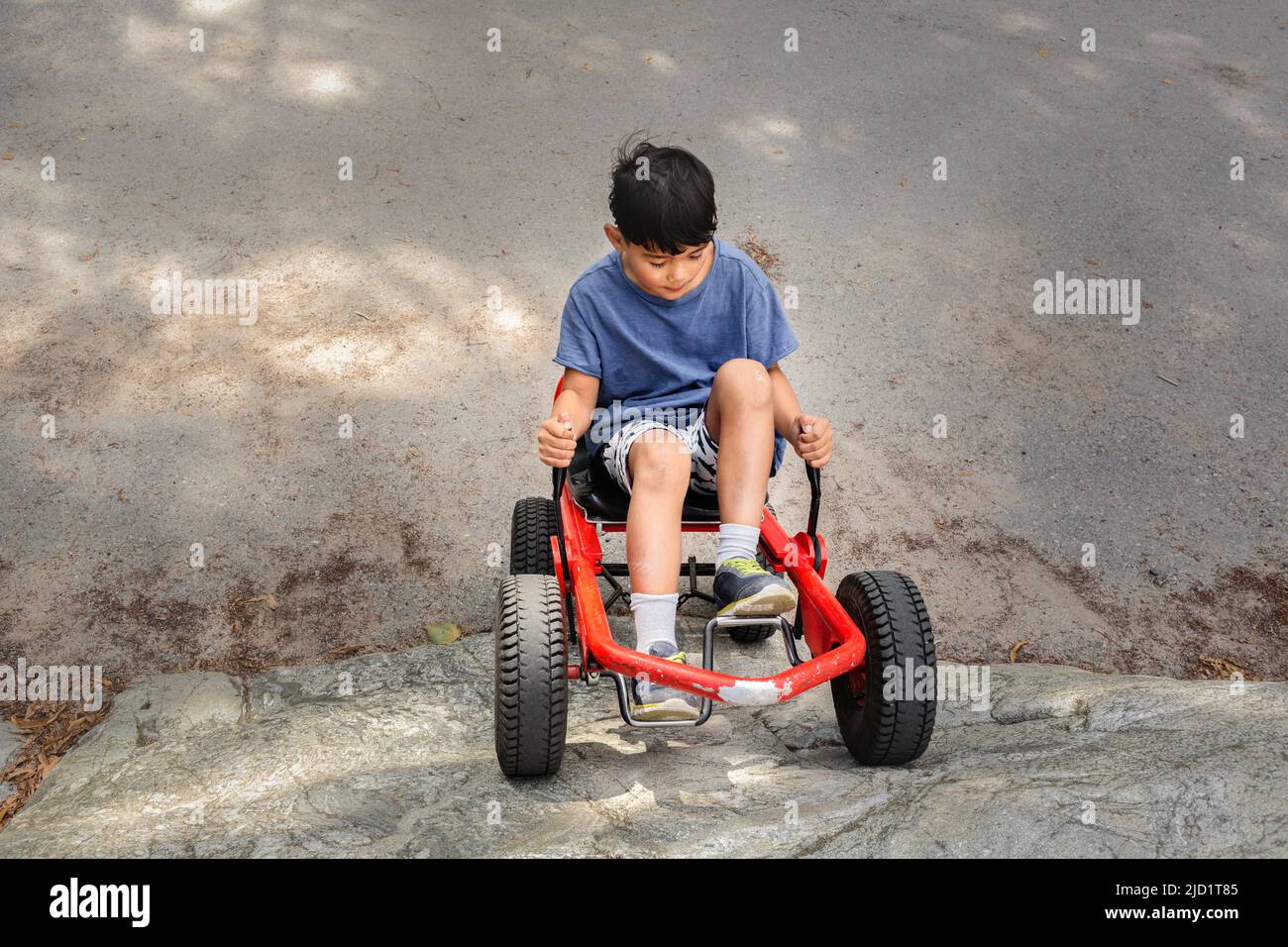 Boy riding cart on rock Stock Photo - Alamy