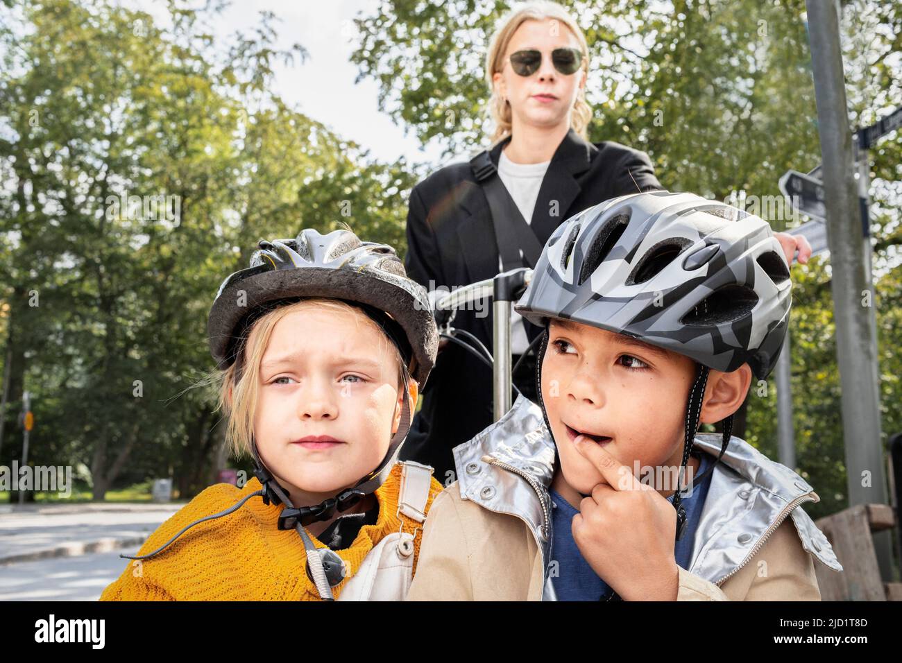 Mother riding bicycle with children in carriage Stock Photo - Alamy