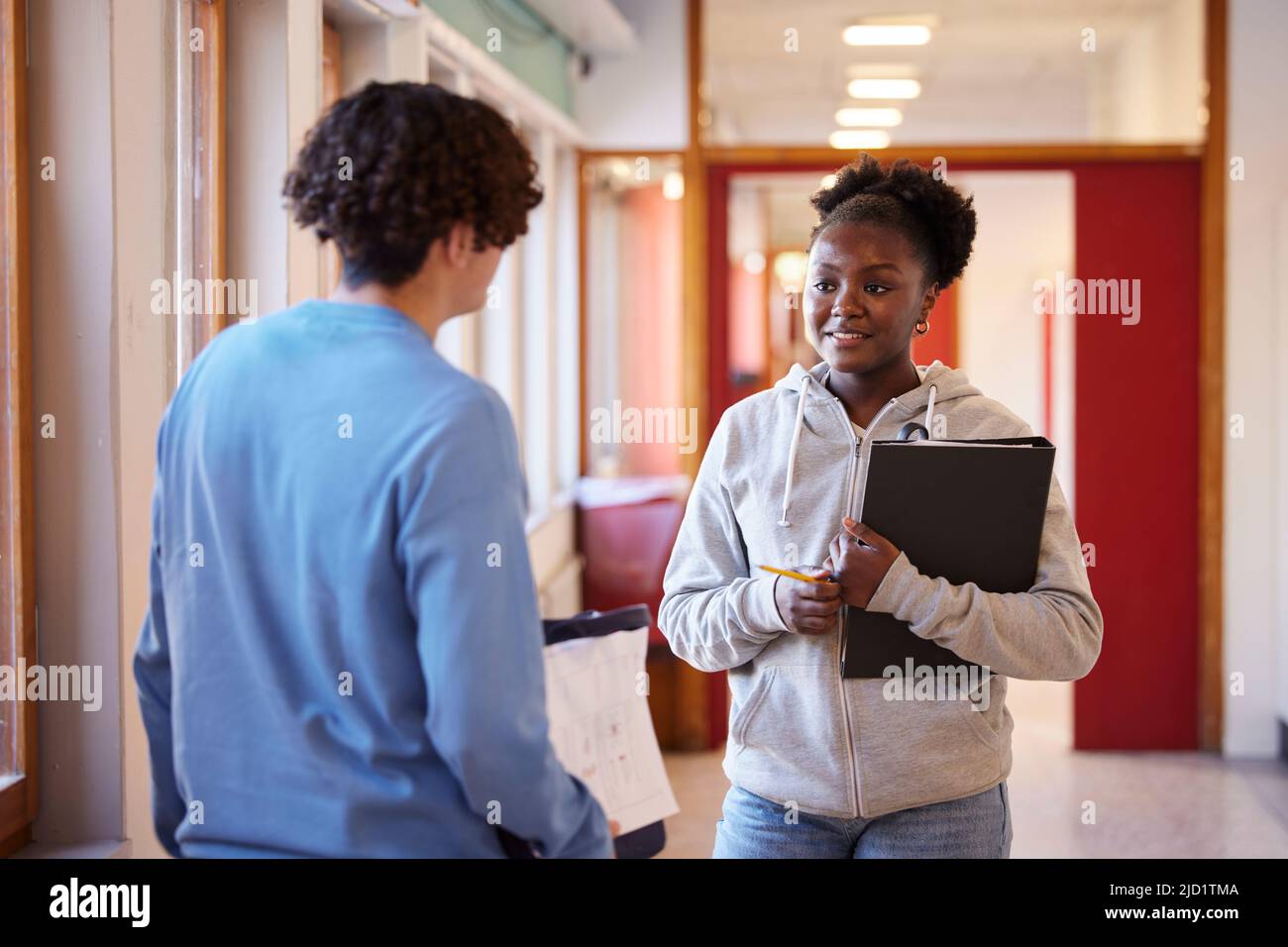 Teenagers talking at corridor Stock Photo - Alamy