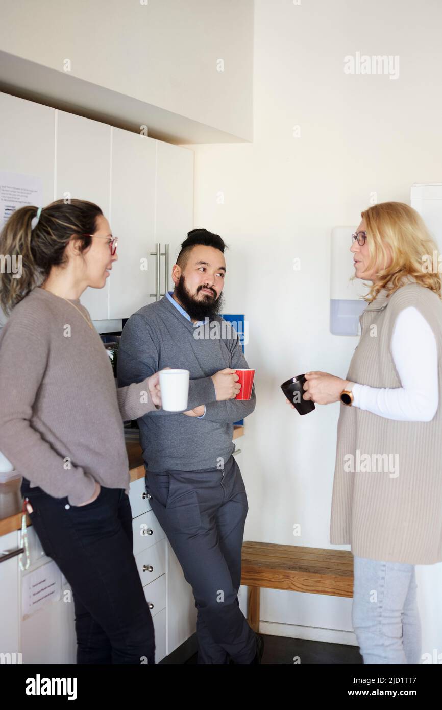 Co-workers talking during coffee break Stock Photo - Alamy