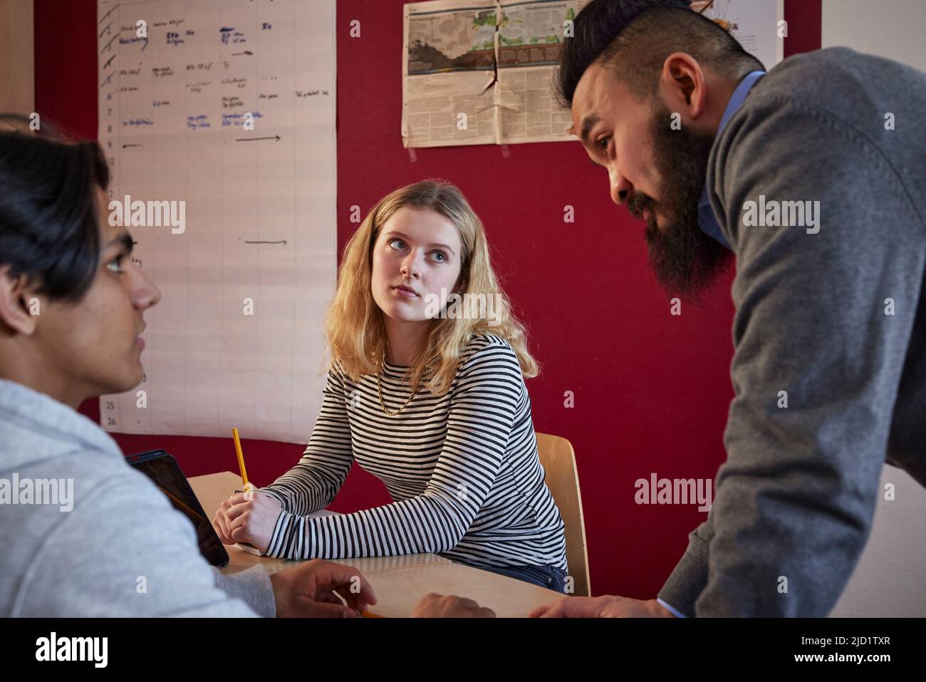 Teacher talking to students in class Stock Photo - Alamy
