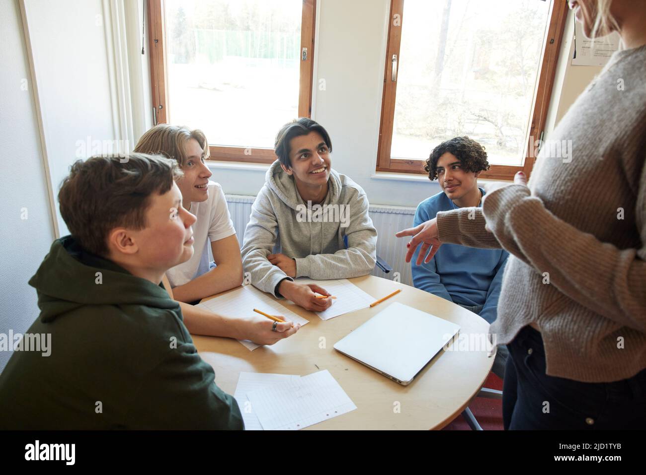Teacher talking to students in class Stock Photo - Alamy