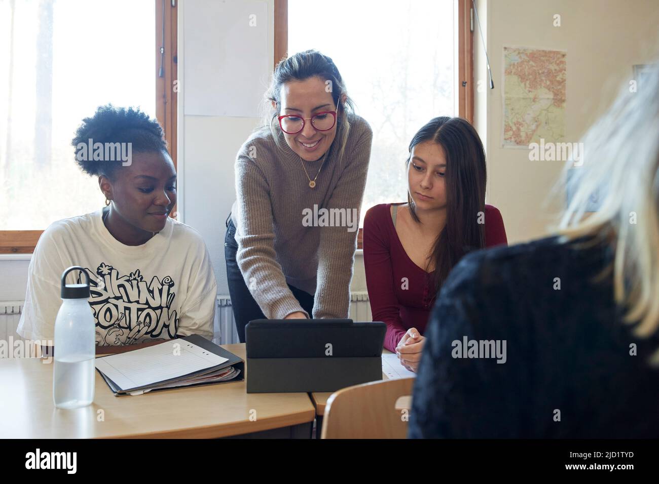Teacher helping students in class Stock Photo - Alamy