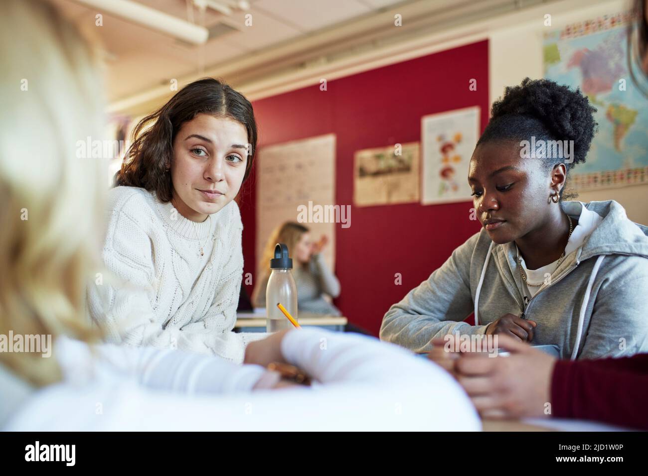 Students talking to teacher in class Stock Photo - Alamy