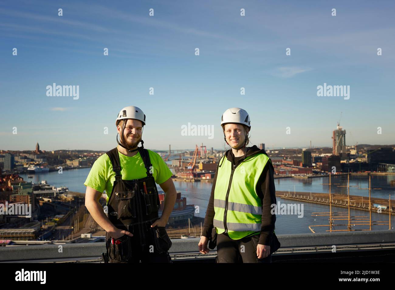 Workers standing on roof Stock Photo - Alamy