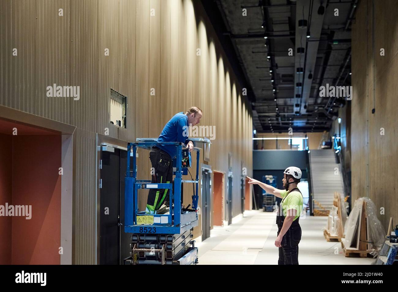 Workers talking at building site Stock Photo - Alamy