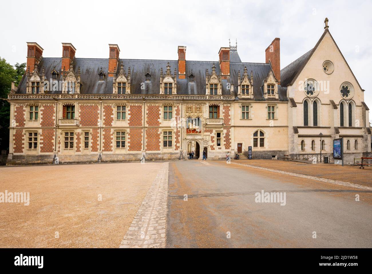 This wing, of red brick and grey stone, forms the main entrance to a ...