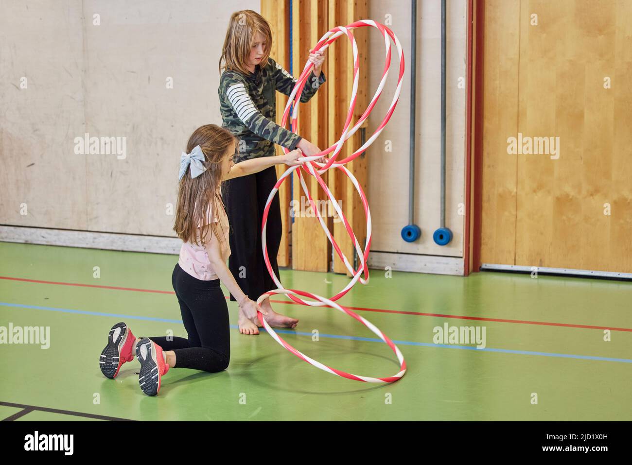 Children playing with hula hoops in school gym Stock Photo - Alamy