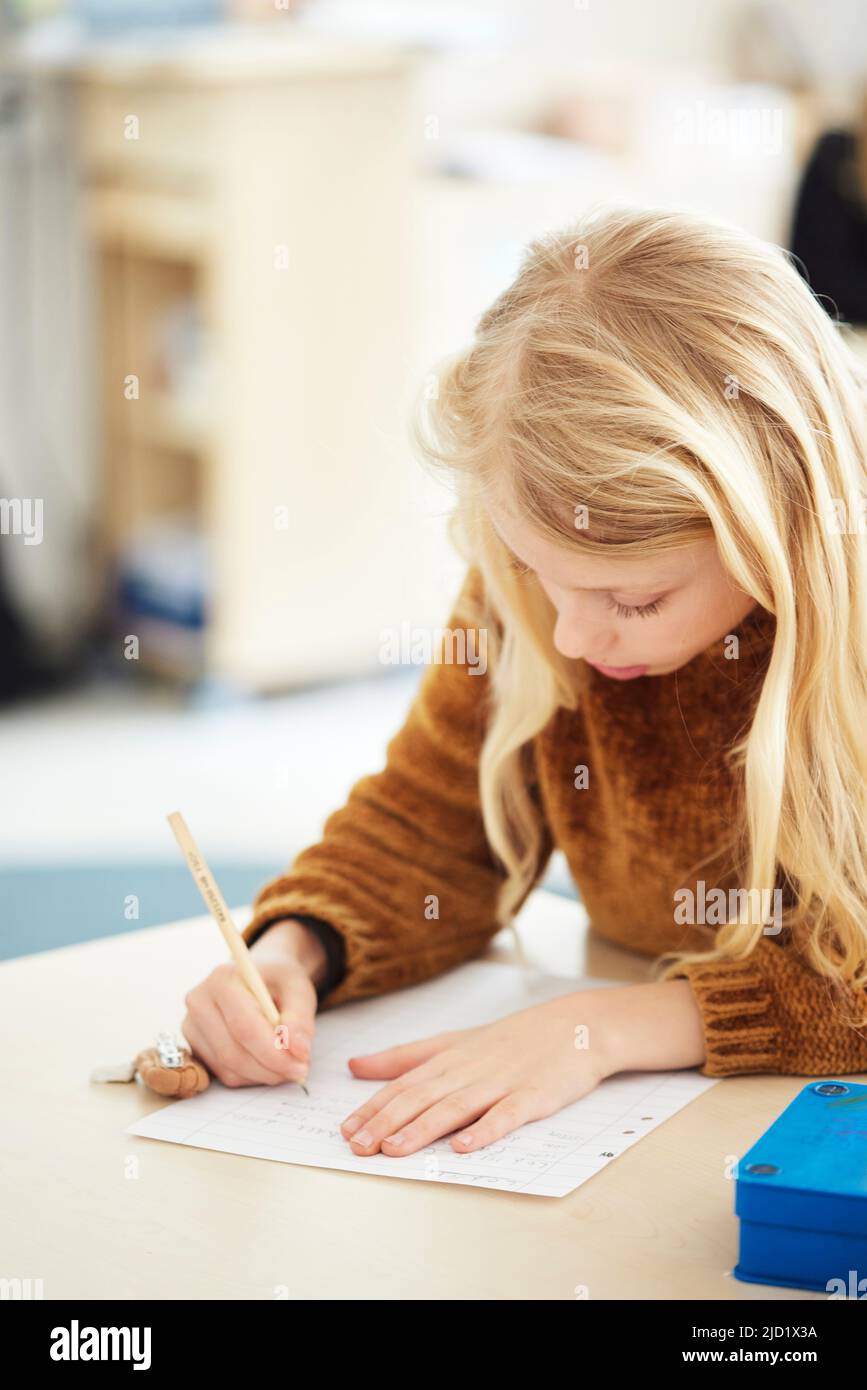Girl doing writing assignment at school Stock Photo - Alamy
