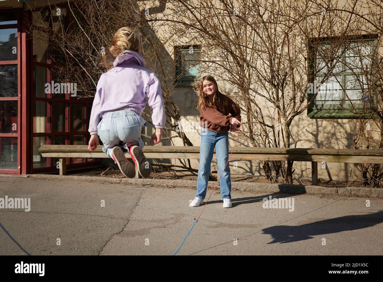 Girls jumping rope outdoors Stock Photo - Alamy